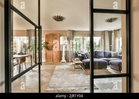 Square table placed on mat near couch and TV in stylish living room of ...