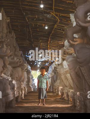 Pileru, India - July 28,2022: Kid holding ganesha idols hand. bonding ...