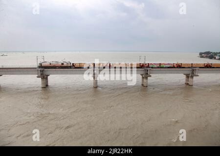 An Indian passenger train passes over a bridge on river Ganges in ...