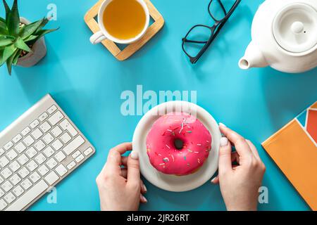 Donut, tea and keyboard on a blue background, flat lay Stock Photo - Alamy