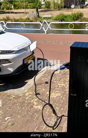 Utrecht, Netherlands - August 2022: Cable plugged in to recharge an ...