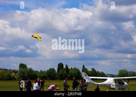Single engine yellow air plane flying at low altitude close to the ...