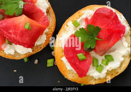 Sandwiches with gravlax, parsley, scallion and cream cheese on black ...