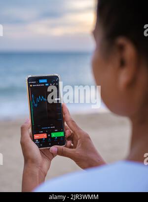 Asian women check Ethereum cryptocurrency on their phone when on ...