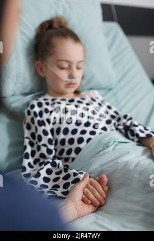 Hospitalized sick child patient resting in bed with family watching ...