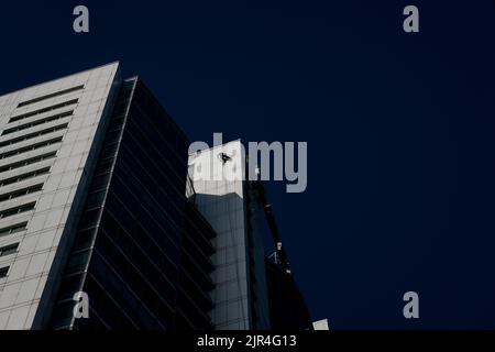 Industrial climber in uniform and helmet rises Stock Photo - Alamy