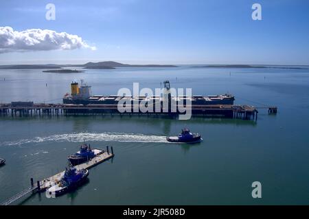 Aerial of tugboat passing the RG Tanna Coal Terminal at Port of ...