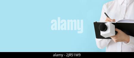Journalist with microphone on light blue background with space for text ...