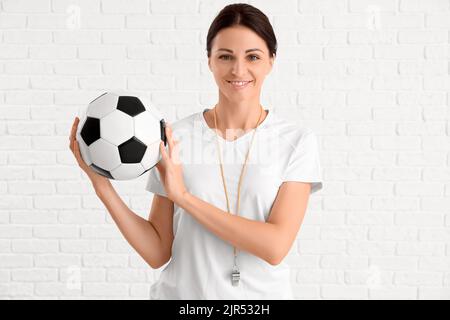 Beautiful PE teacher on white brick background Stock Photo - Alamy