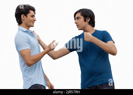 One teenage boy pulling the other by the collar of his shirt against ...