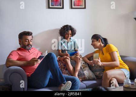 Happy nuclear family using smartphone in living room Stock Photo - Alamy
