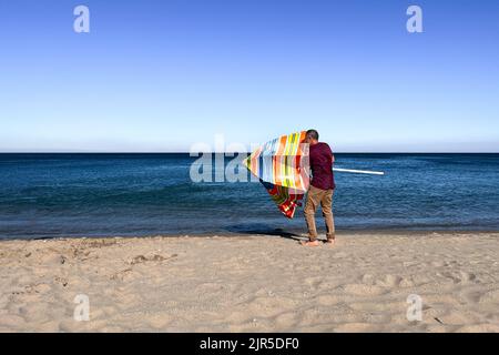 man holding an open parasol on the beach Stock Photo - Alamy
