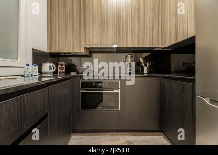 Kitchen with chestnut wood cabinets with light-coloured countertops ...