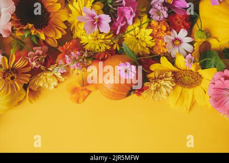 Colorful autumn flowers, pumpkins, pattypan squashes flat lay on yellow ...