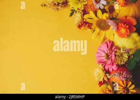 Colorful autumn flowers, pumpkins, pattypan squashes flat lay on yellow ...
