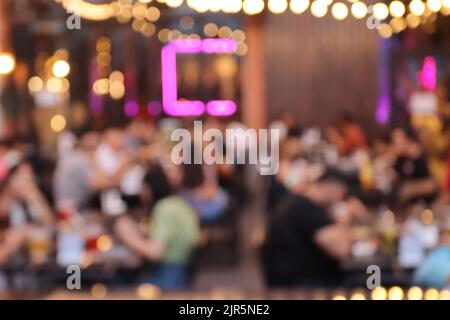 blurred image at the restaurant night time, many people in the ...