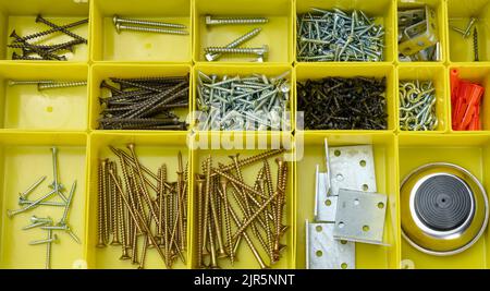 Various metal screws in separate yellow plastic containers Stock Photo ...