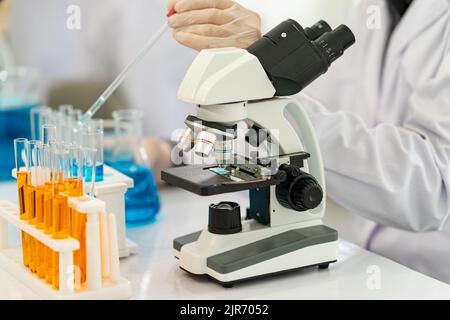 scientist doing research on plants holding a green solution in a test ...