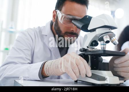 scientist doing research on plants holding a green solution in a test ...