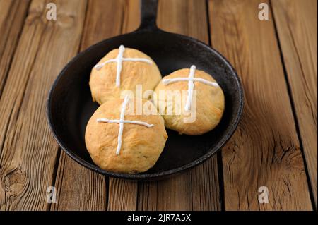 Hot cross buns in cast iron skillet on wooden background with space ...