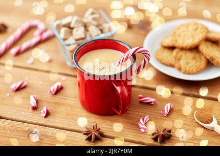 cup of eggnog with candy cane, cookies and sugar Stock Photo - Alamy