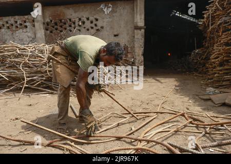 Bangladeshi workers are seen working in the steel re-rolling mill ...