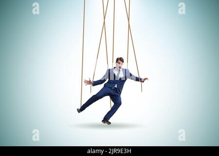 Businessman puppet being manipulated by the ropes Stock Photo - Alamy