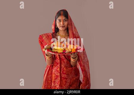 woman from Bihar offers prayers to the sun in the early morning hours ...