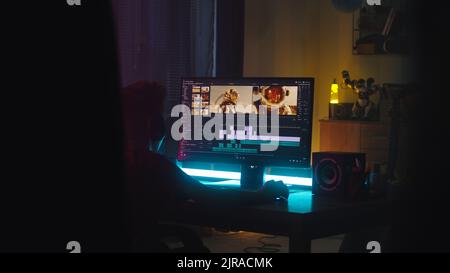 Teenager using computer to edit footage while sitting at desk in ...