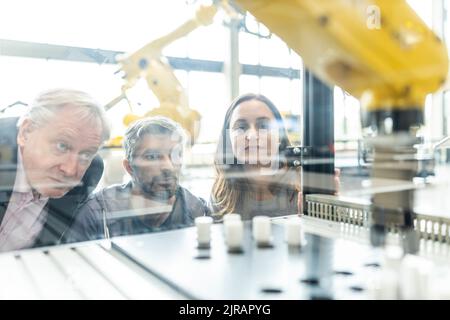 Technicians testing and observing new industrial robot Stock Photo - Alamy
