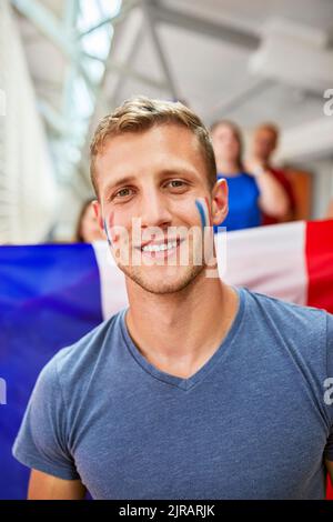 Smiling man with French Flag painted on face at stadium Stock Photo - Alamy