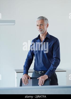 Businessman standing behind an office chair isolated on white ...