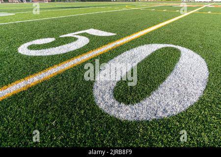 Synthetic turf football field fifty, 50, yard line in white Stock Photo ...