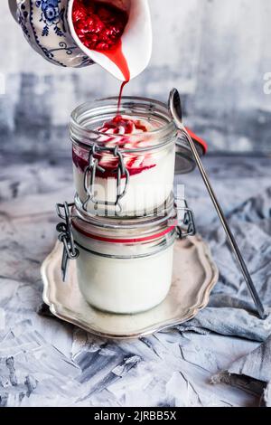 Raspberry topping pouring on homemade frozen yogurt Stock Photo - Alamy