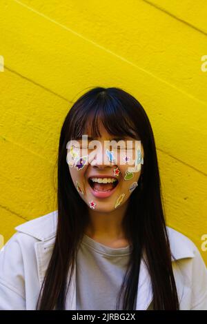 Young black woman with stickers on her face showing peace sign isolated ...