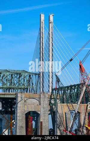 An old bridge is under demolition next to a new cable-stayed bridge ...