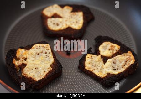 Three cheese sandwiches burned in the pan to black Stock Photo - Alamy