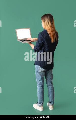 Transgender programmer with laptop on green background Stock Photo - Alamy