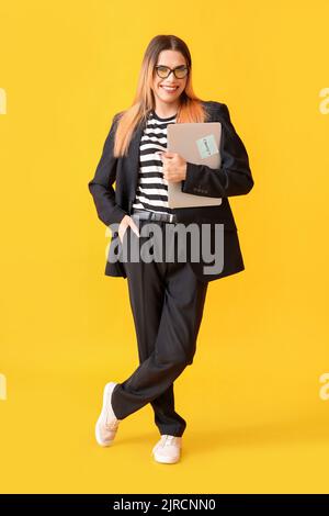 Transgender programmer with laptop on yellow background Stock Photo - Alamy