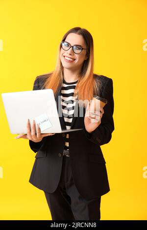 Transgender programmer with laptop on yellow background Stock Photo - Alamy