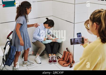 School bullying scene with children recording fight on smartphone ...