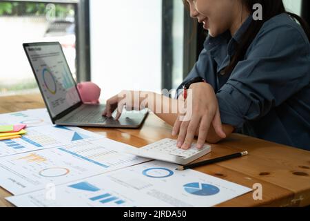businesswoman accountant working using a calculator and laptop computer ...