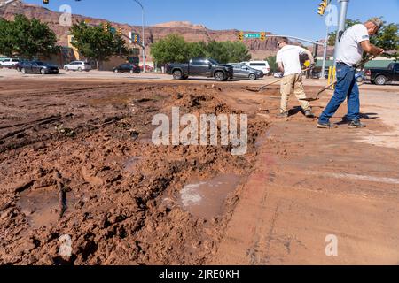 Volunteers shovel mud from the front of a local business the day after ...
