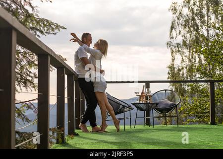 Horizontal sideview shot of a young couple in summer outfit enjoying ...