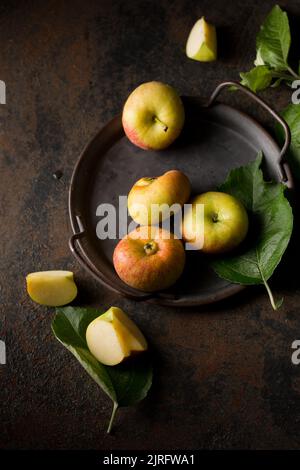 Small flattened apples on a metal tray on a dark background Stock Photo ...