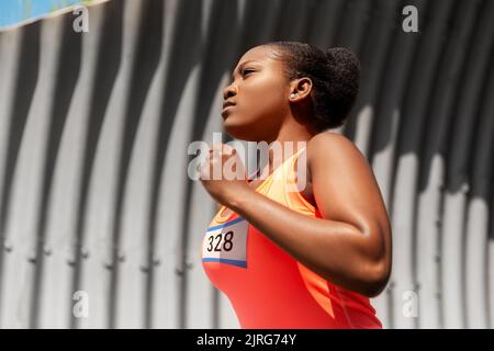 young african american sportswoman running on stadium near 2020 ...