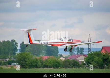 An airplane flying over a greenery landscape at Hangariada aeronautical ...