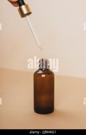 Brown dropper with anti-aging face serum with christmas ball on bokeh ...