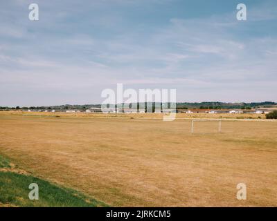 Smallgains playing fields with brown dry grass and new tree plantings ...