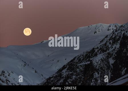 Full moon shining over snowy Pyrenees mountain range covered with snow ...